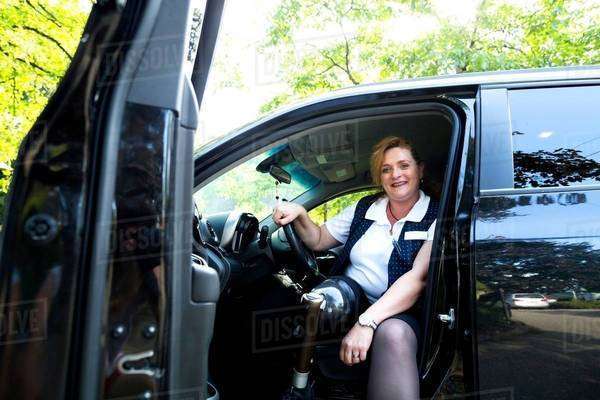 Portrait of mid adult woman with prosthetic leg, sitting in car - Stock ...