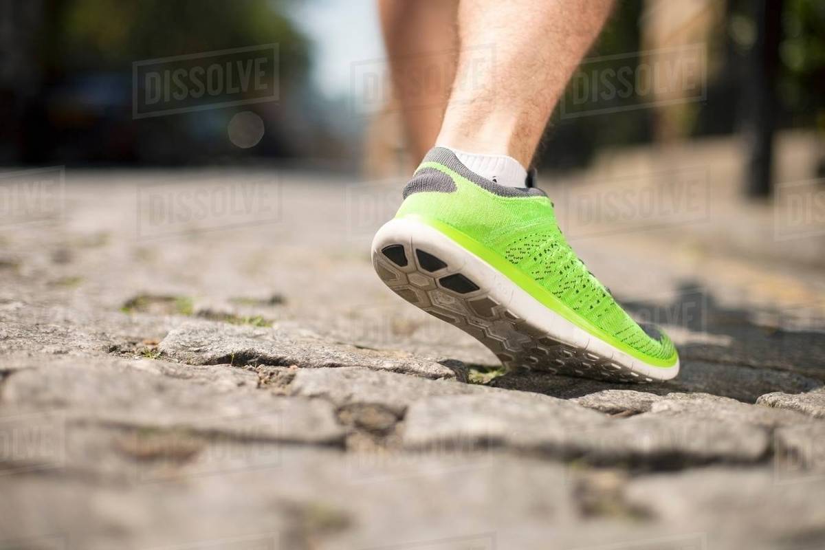 Runner jogging on cobbled street - Royalty-free Stock Photo | Dissolve