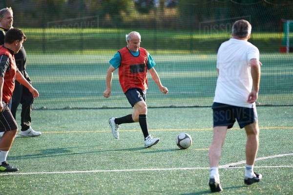 Senior man playing football - Stock Photo - Dissolve