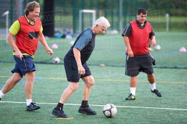 Men playing football - Stock Photo - Dissolve