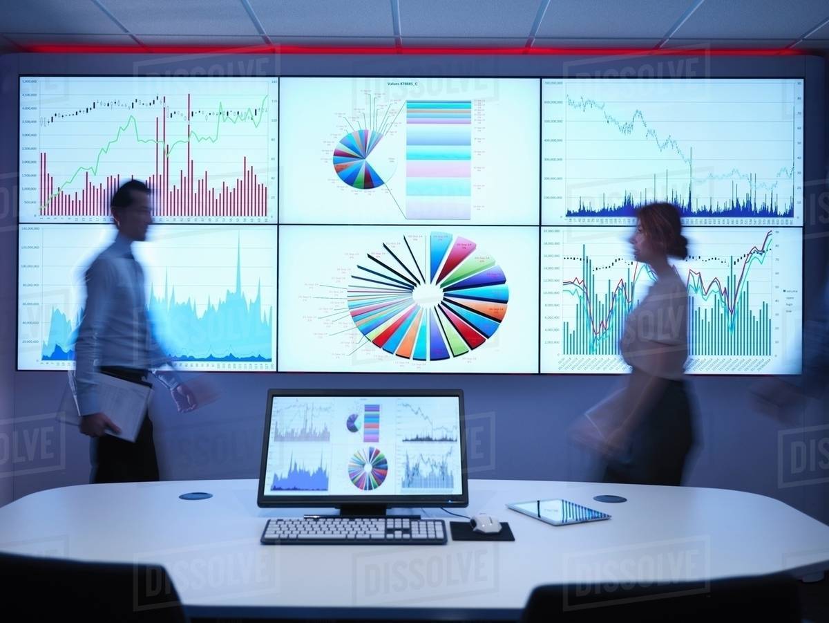 Business people walking in front of graphs on screen - Stock Photo ...