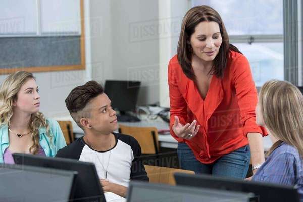 Teacher explaining to high school students in class - Royalty-free ...