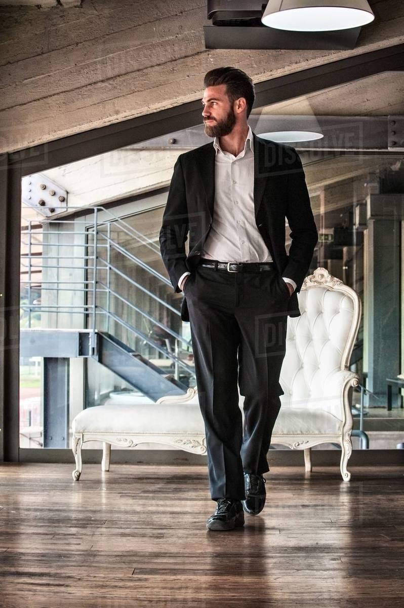 Full length front view of mid adult man wearing suit hands in pockets ...