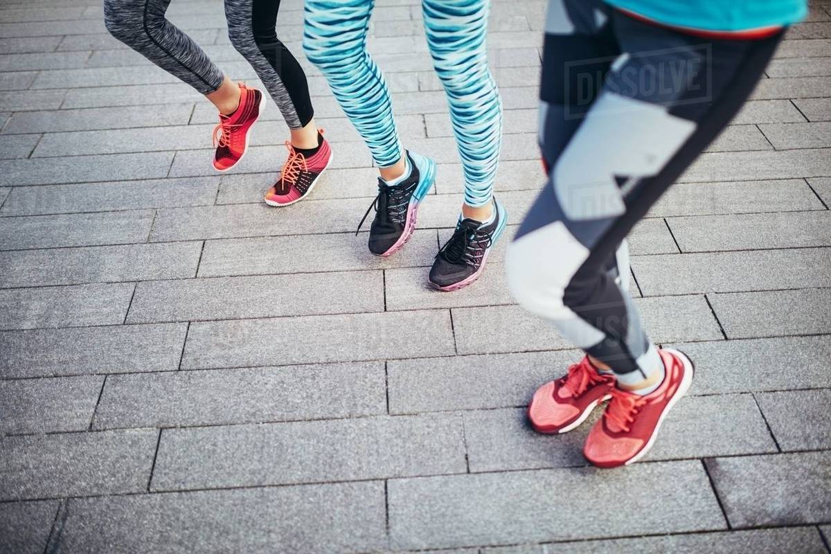 Legs of three female runners running on spot - Stock Photo - Dissolve