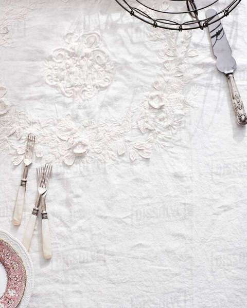 Overhead view of cutlery on white traditional tea tablecloth - Stock ...