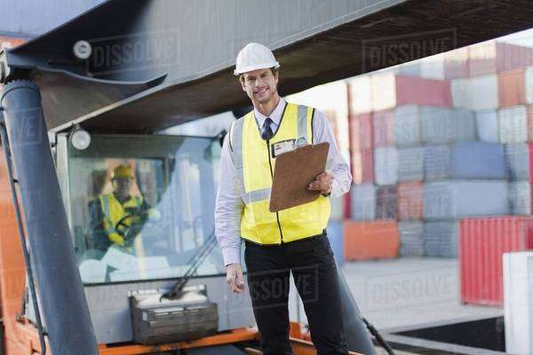 Worker standing on machinery on site - Royalty-free Stock Photo | Dissolve