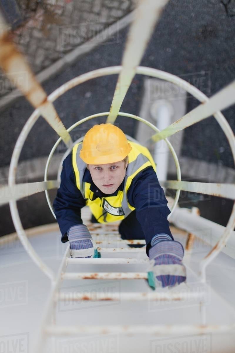 Worker climbing ladder on site - Royalty-free Stock Photo | Dissolve