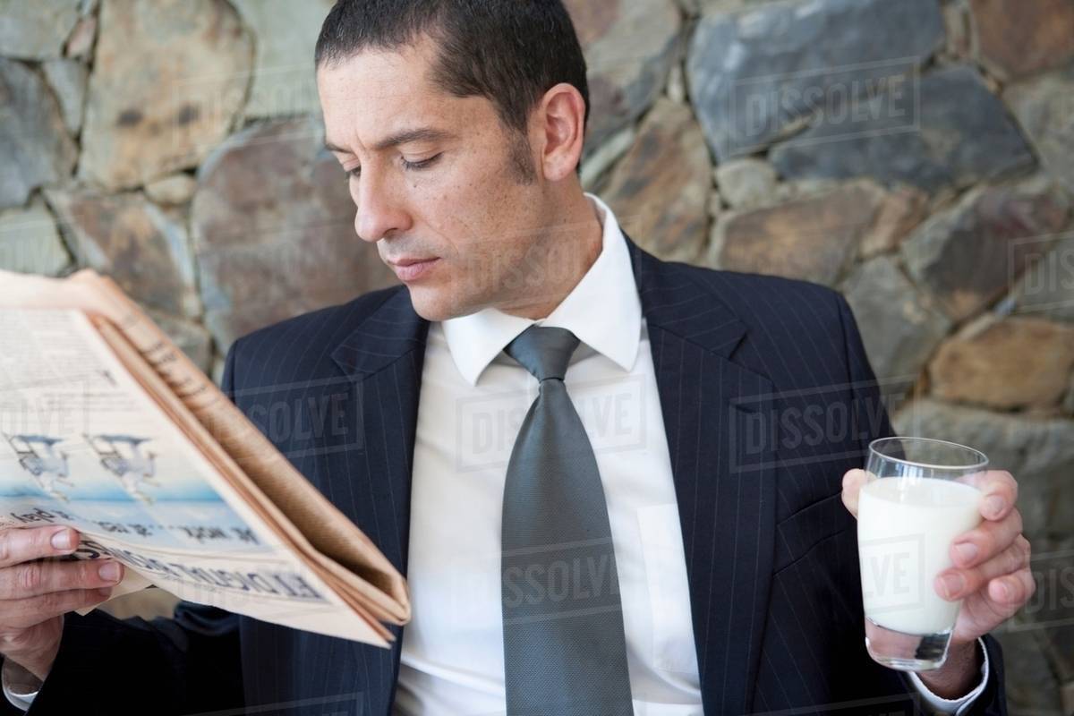 Businessman reading newspaper - Stock Photo - Dissolve