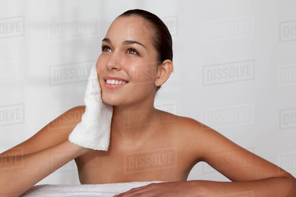 Woman scrubbing her face with cloth - Royalty-free Stock Photo | Dissolve