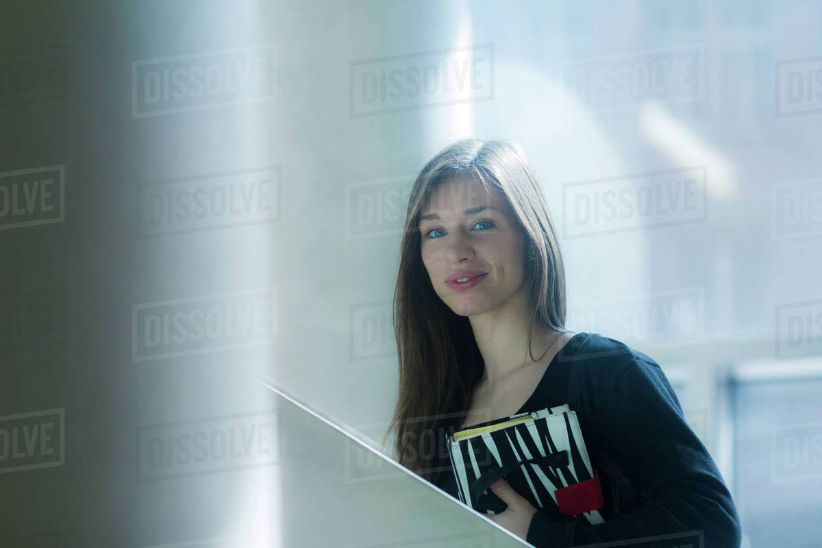 Woman carrying notebook looking at camera smiling - Royalty-free Stock ...