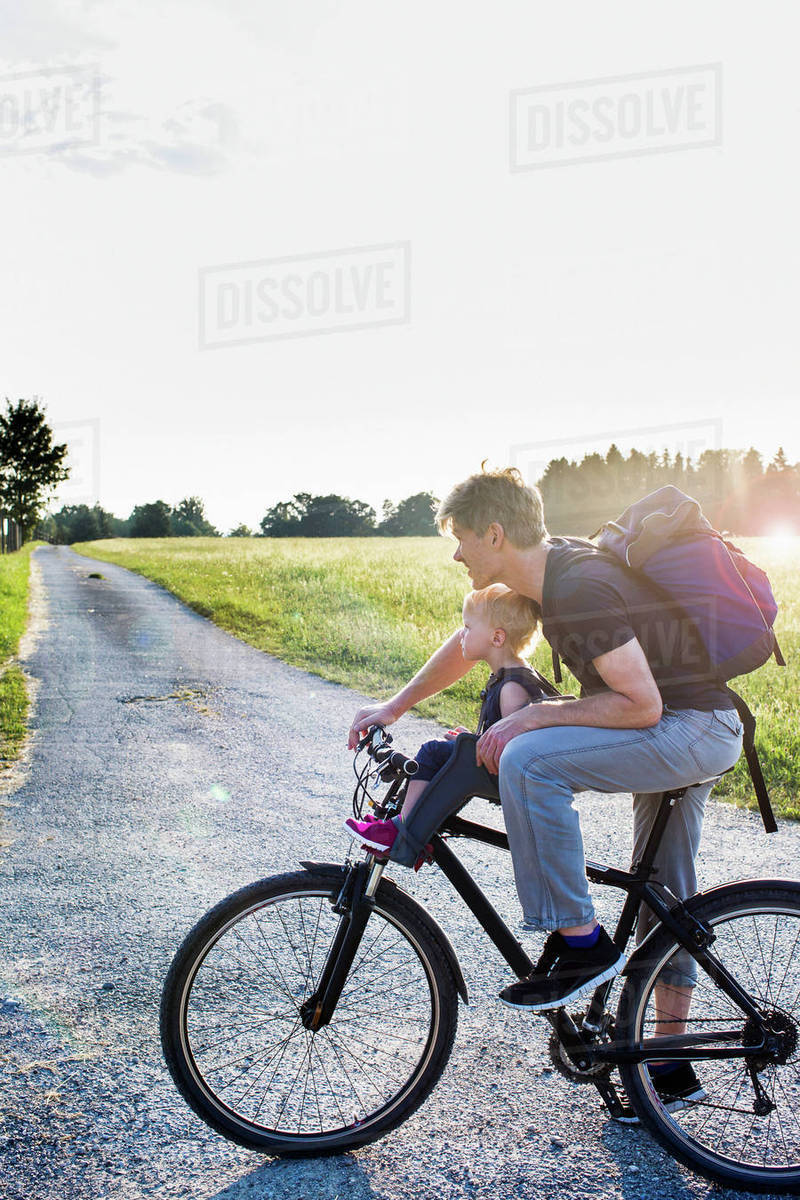 Father and baby daughter riding bike together - Royalty-free Stock ...