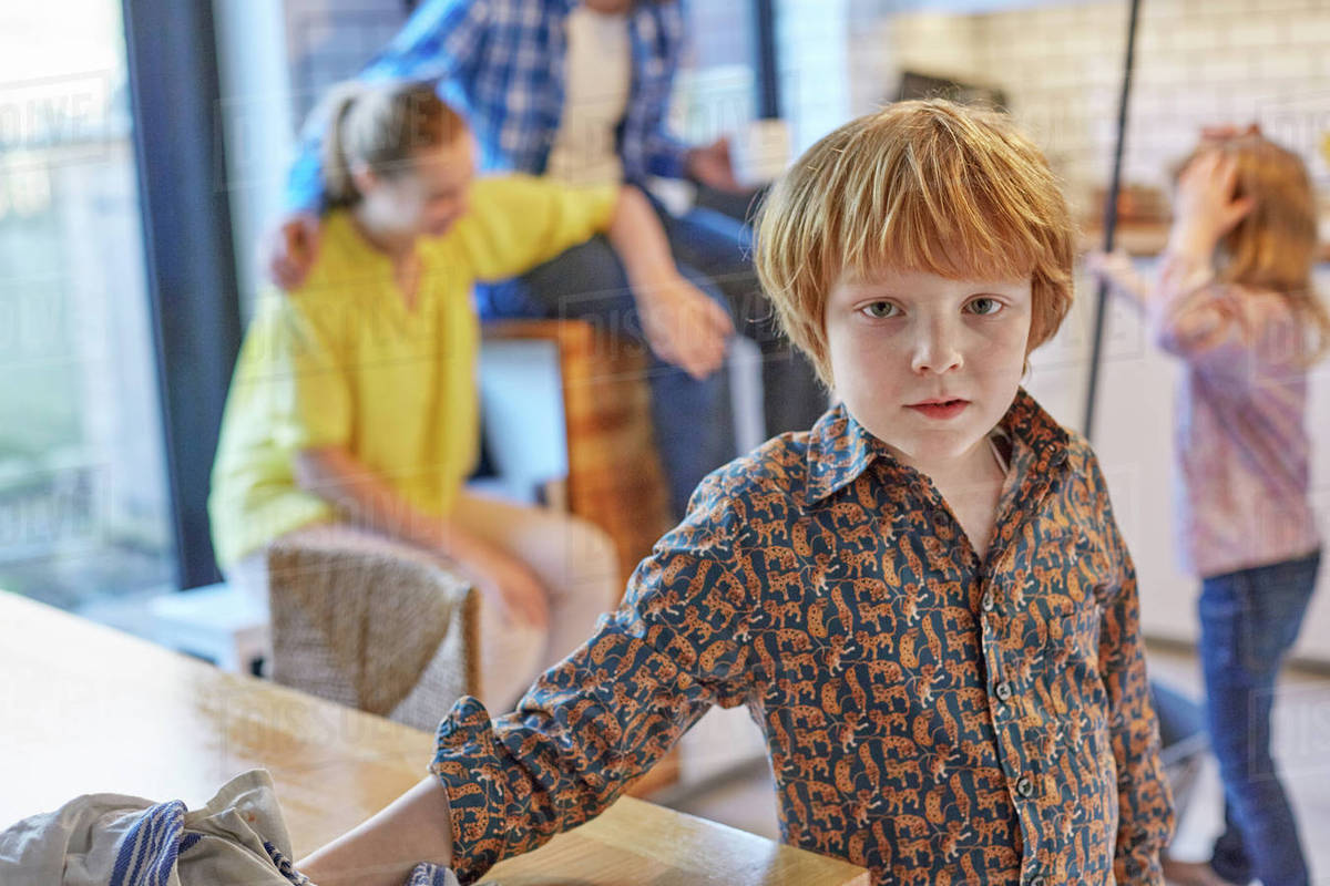 Boy wiping dining table, people in background - Stock Photo - Dissolve