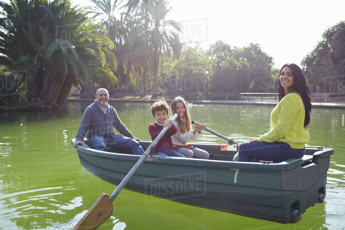 Family in rowing boat on lake looking at camera smiling - Stock Photo ...