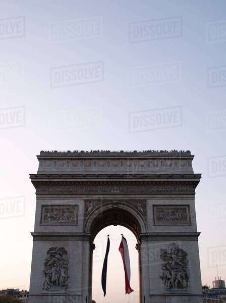 The French national flag hanging from the famous landmark, the Arc De ...