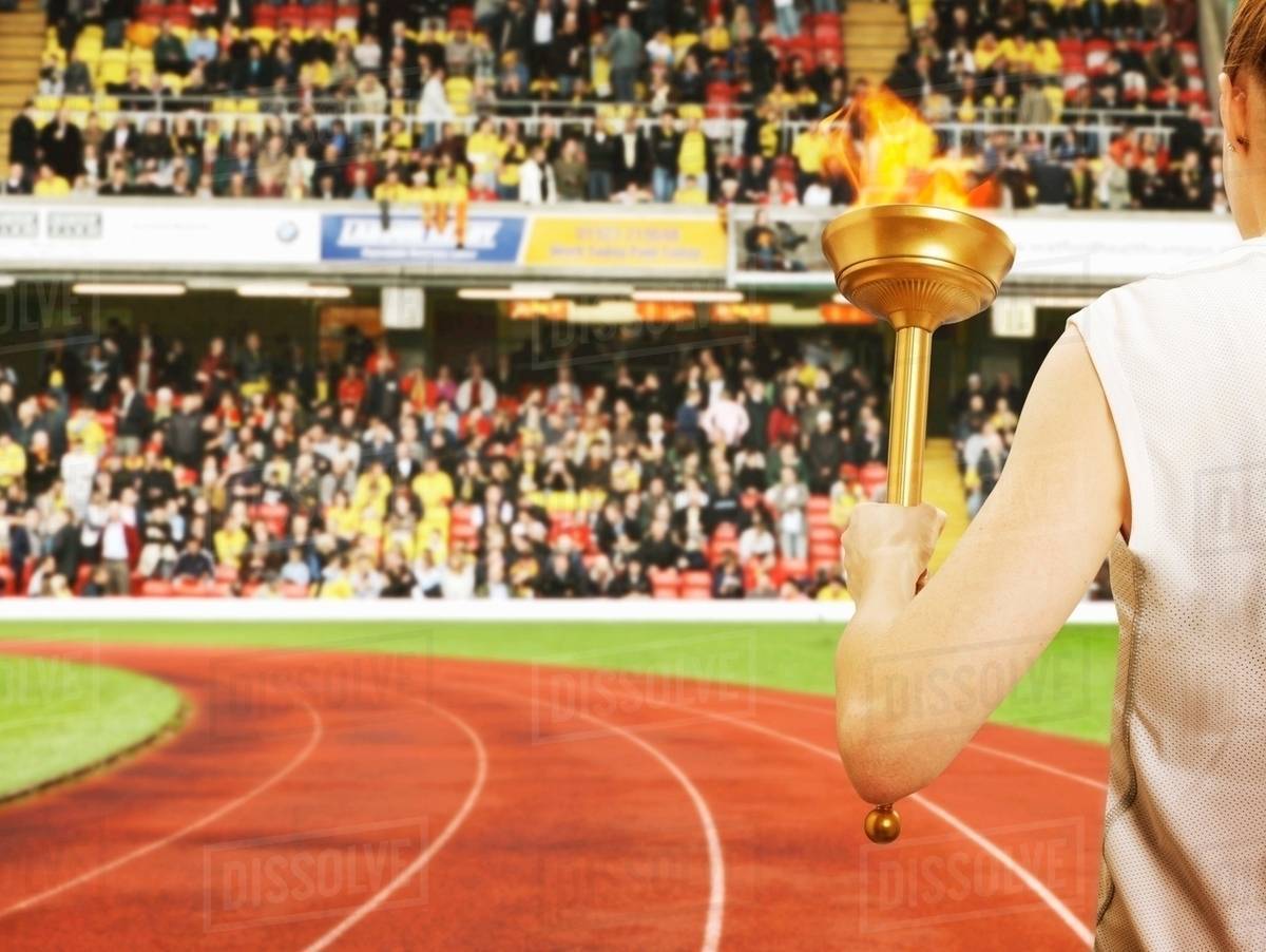 Runner on track with flaming baton - Stock Photo - Dissolve