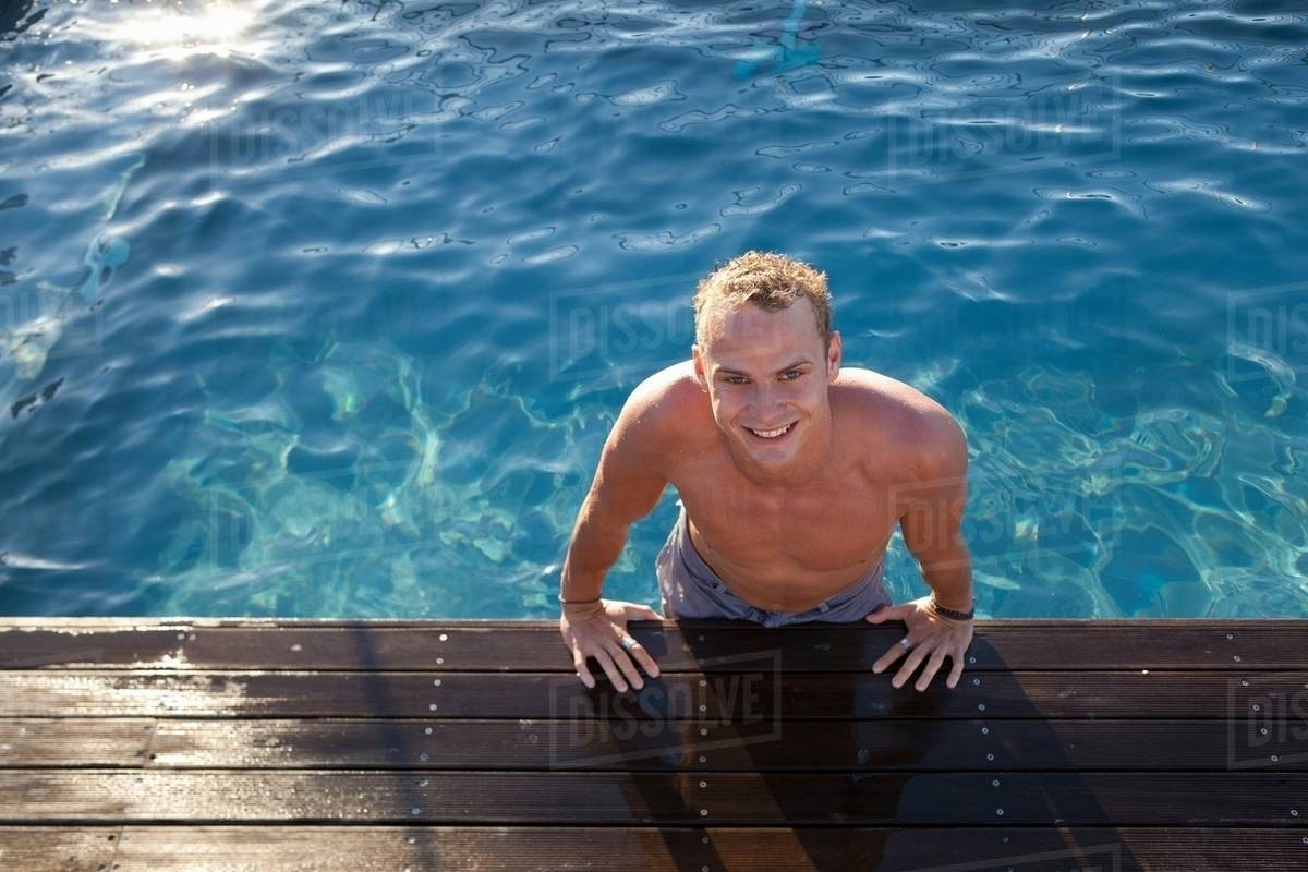Man climbing out of swimming pool - Royalty-free Stock Photo | Dissolve