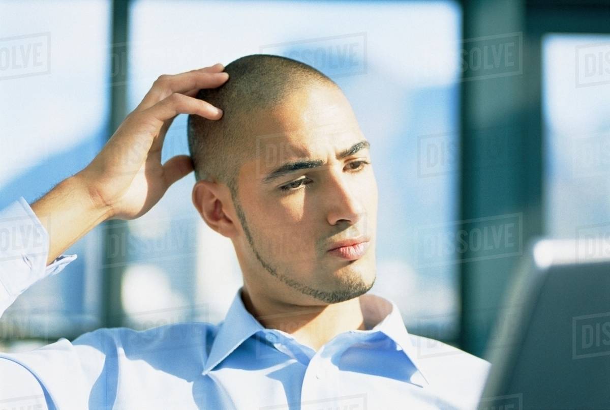 Businessman scratching his head - Stock Photo - Dissolve
