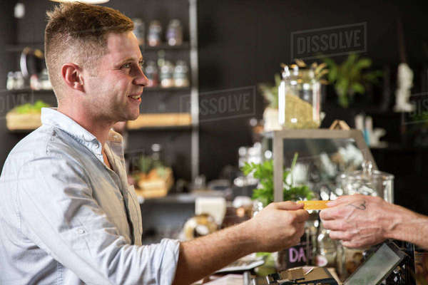 Customer handing smiling restaurant worker credit card - Stock Photo ...