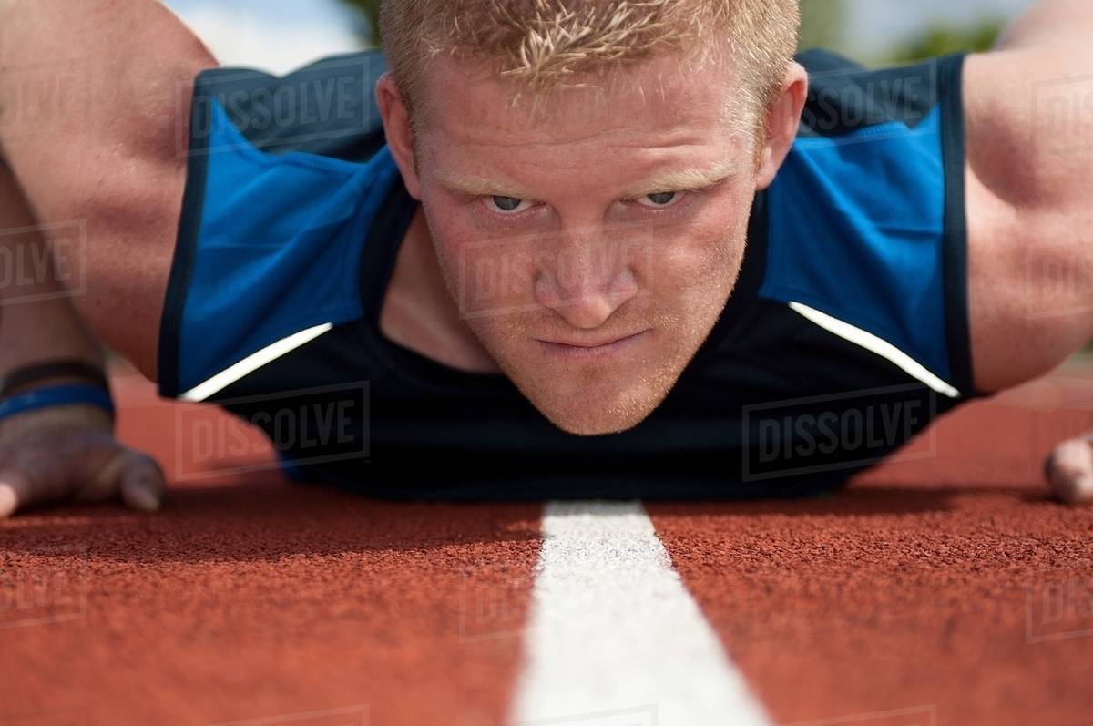 Athlete doing push ups on track - Stock Photo - Dissolve