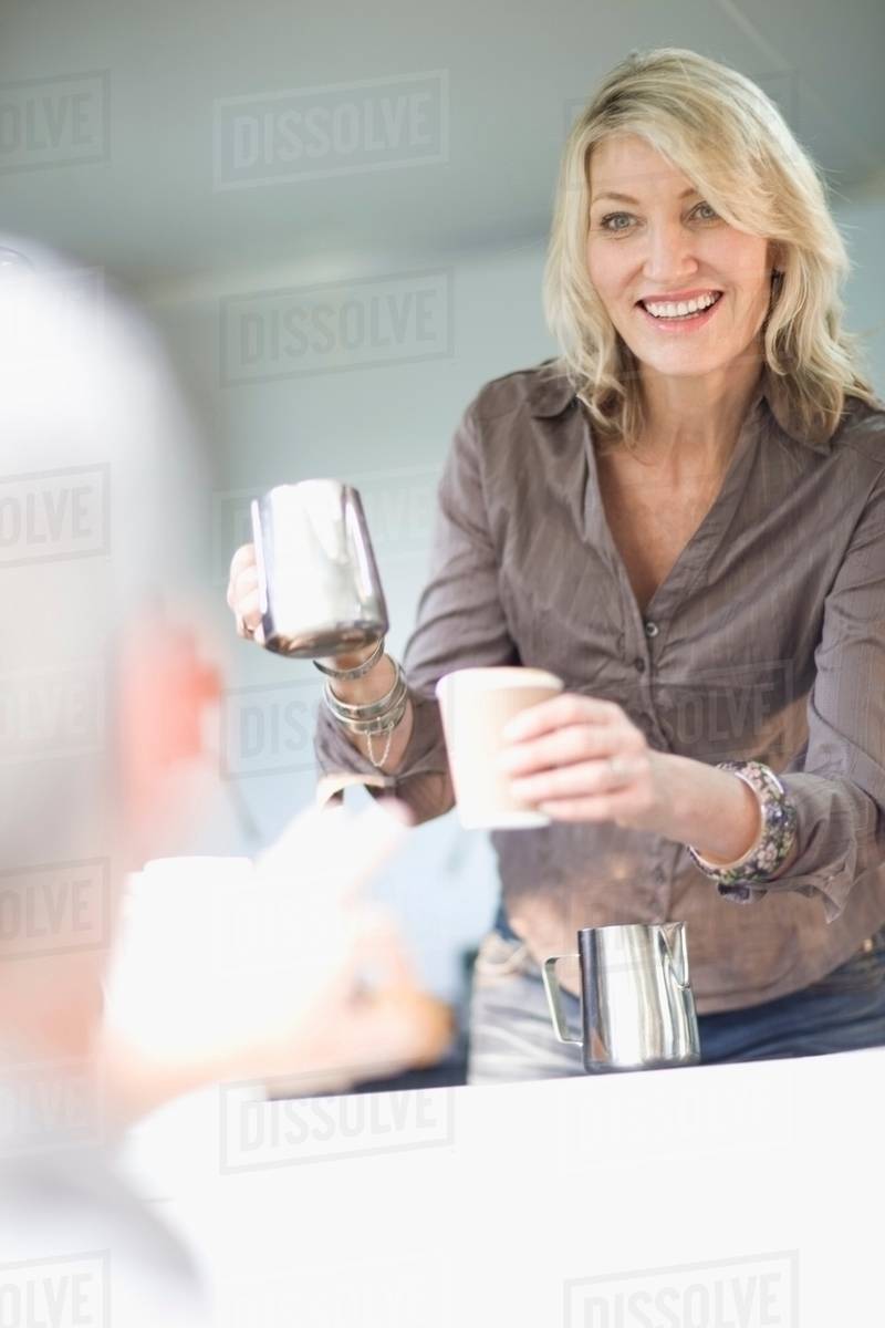 Woman serving coffee in food cart - Stock Photo - Dissolve