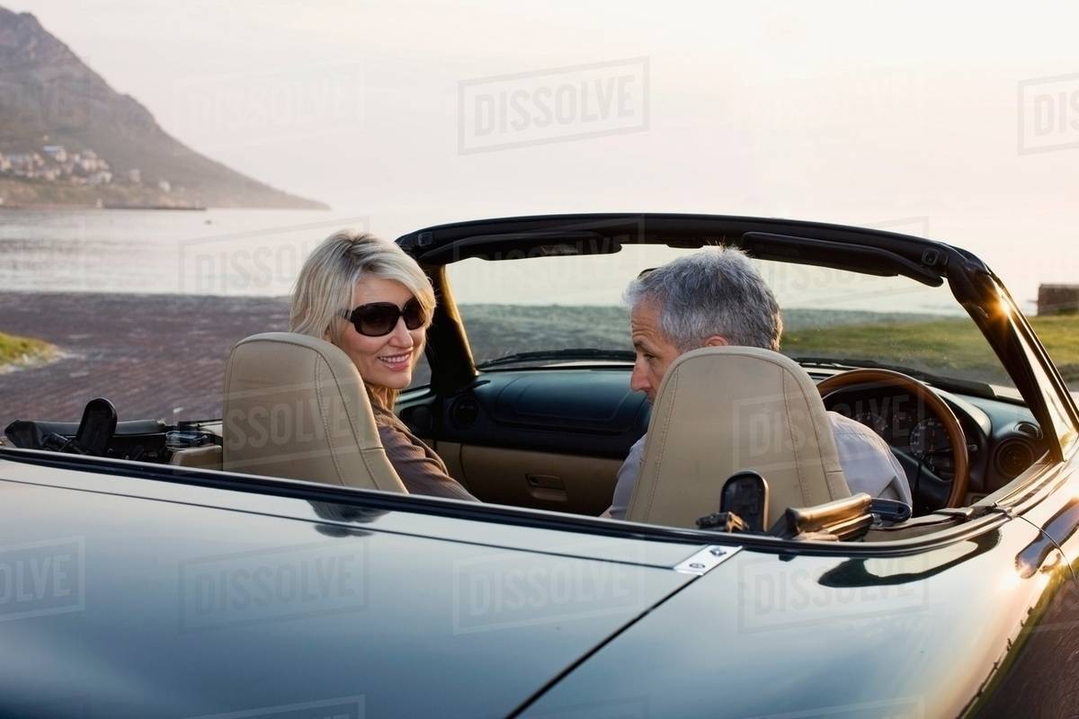 Couple in convertible admiring coastline - Royalty-free Stock Photo ...