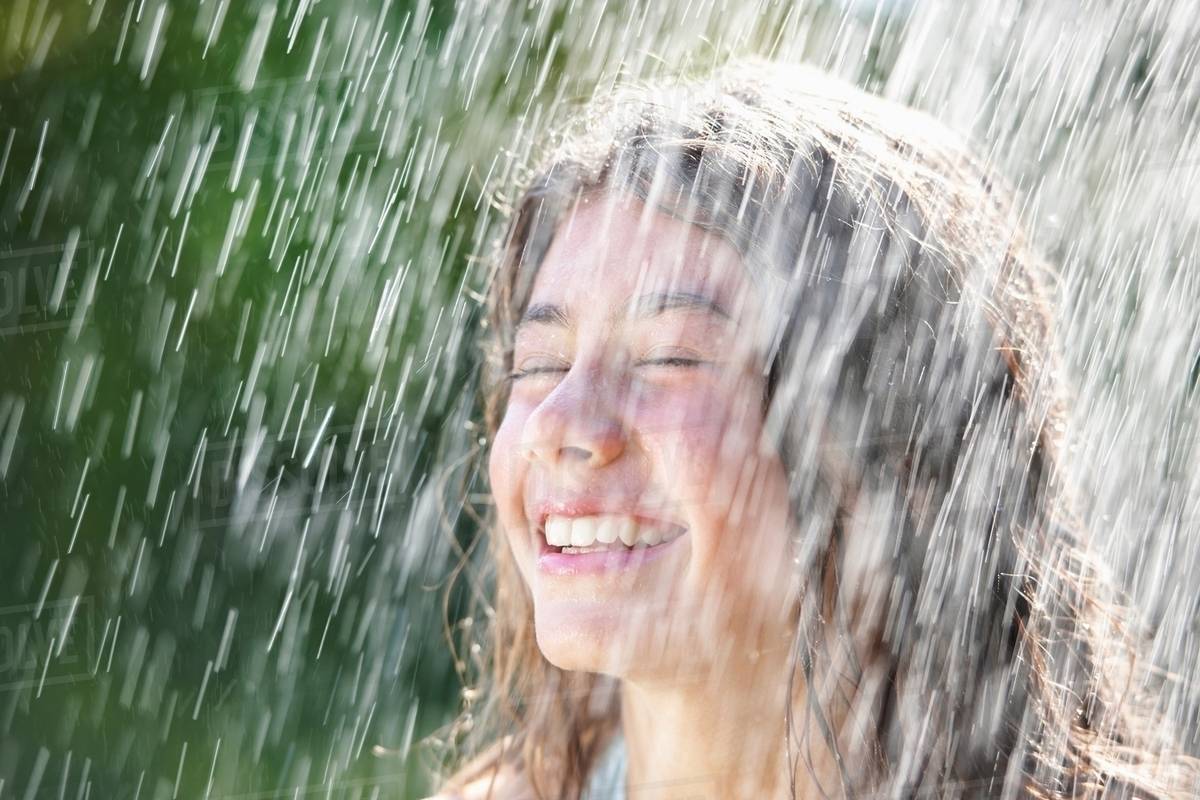 Girl playing in rain - Stock Photo - Dissolve