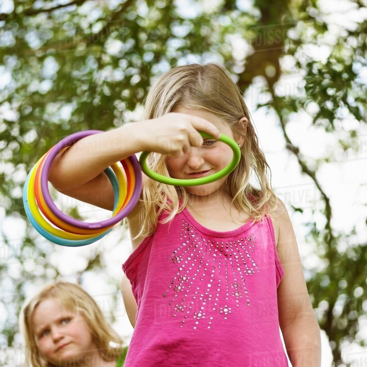 Girl throwing rings outdoors - Royalty-free Stock Photo | Dissolve