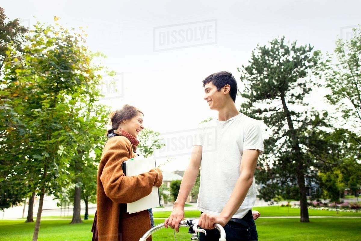 Smiling couple talking in park - Stock Photo - Dissolve