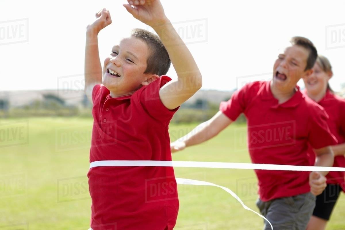Boy cheering and crossing finish line - Stock Photo - Dissolve