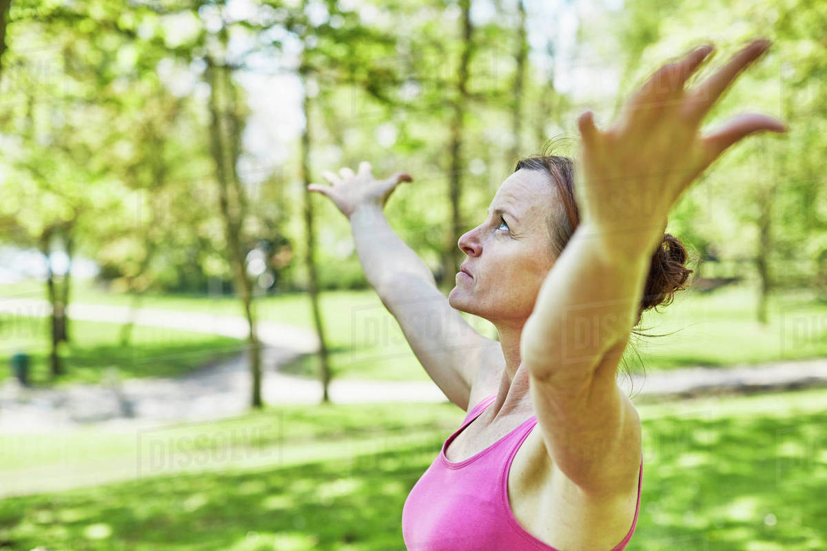 Side view of woman looking up arms raised stretching - Royalty-free ...