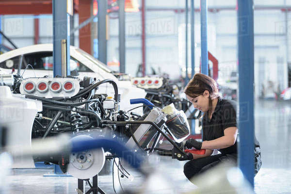 Female engineer assembles car in racing car factory - Stock Photo ...