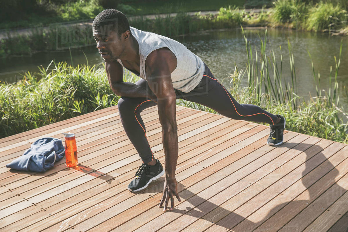 Man lunging on decking - Royalty-free Stock Photo | Dissolve