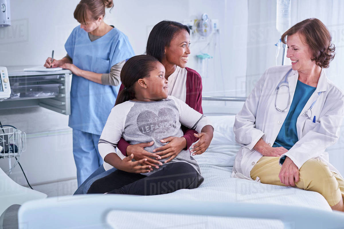 Girl patient and her mother talking to female doctor on hospital ...