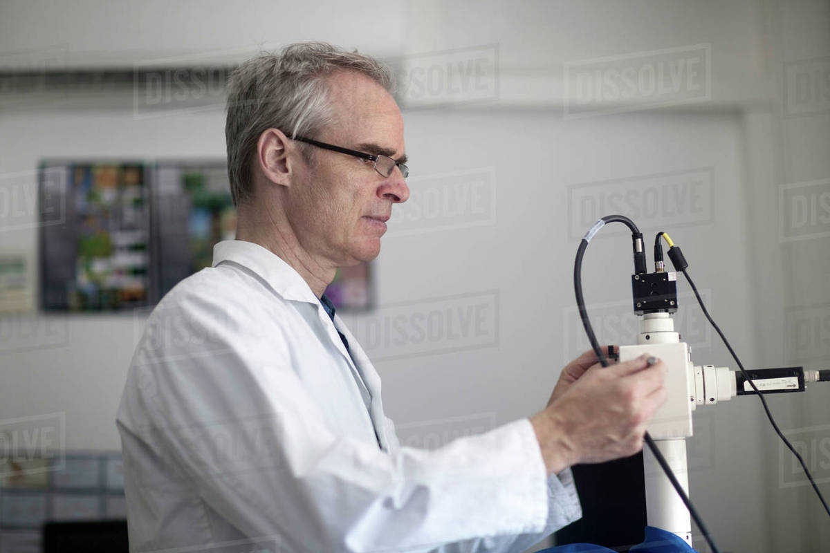 Male meteorologist using equipment in weather station laboratory ...