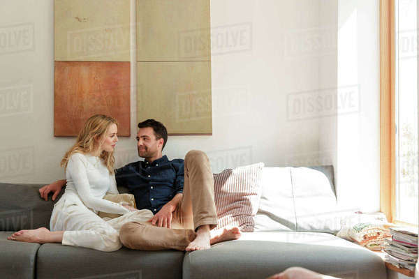 Couple snuggling on sofa - Royalty-free Stock Photo | Dissolve