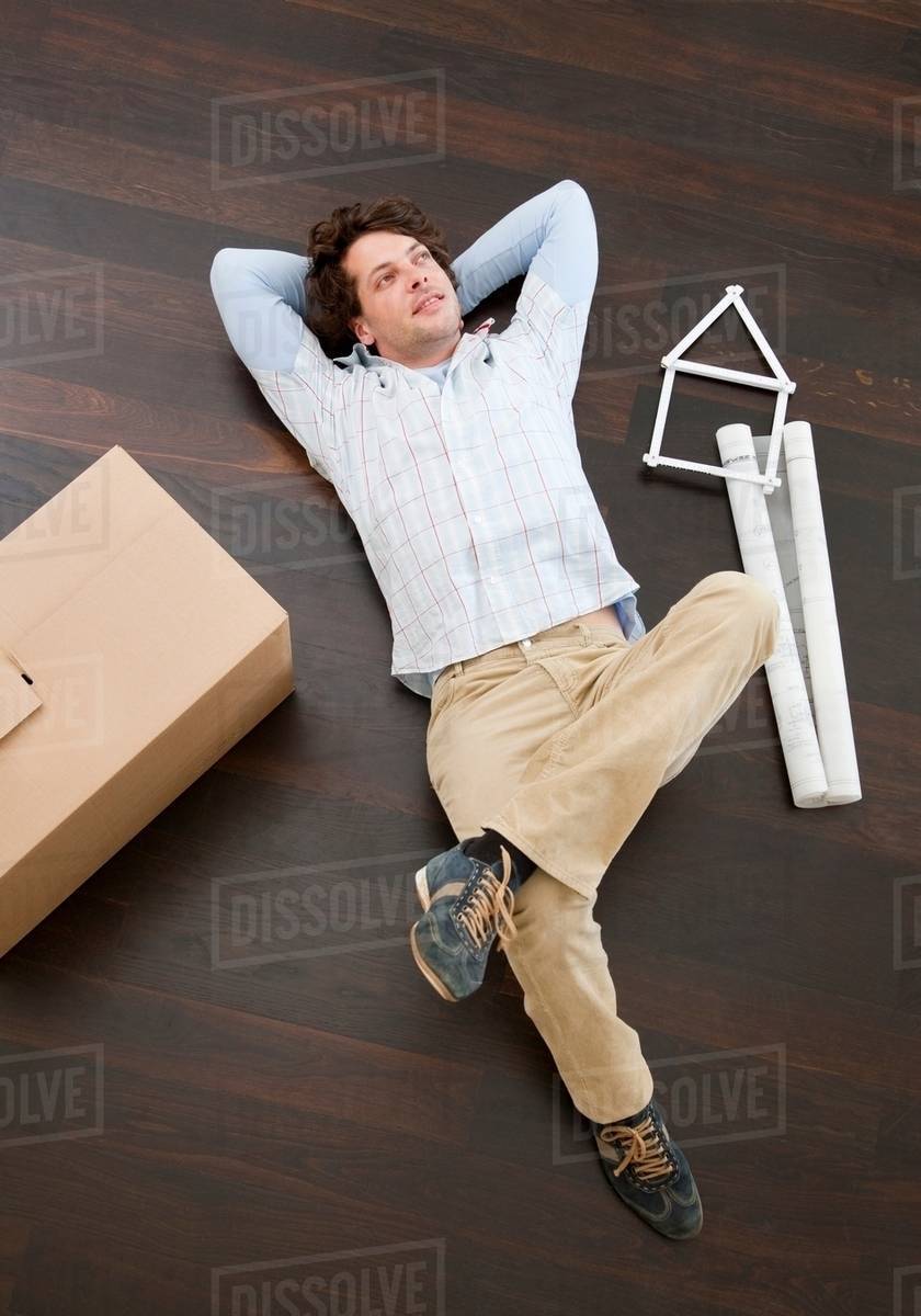 Man laying on floor with boxes - Stock Photo - Dissolve