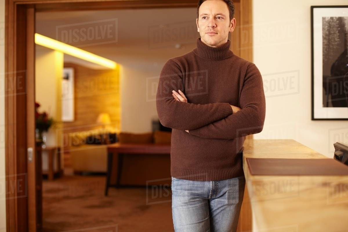 Man standing at hotel front desk - Stock Photo - Dissolve