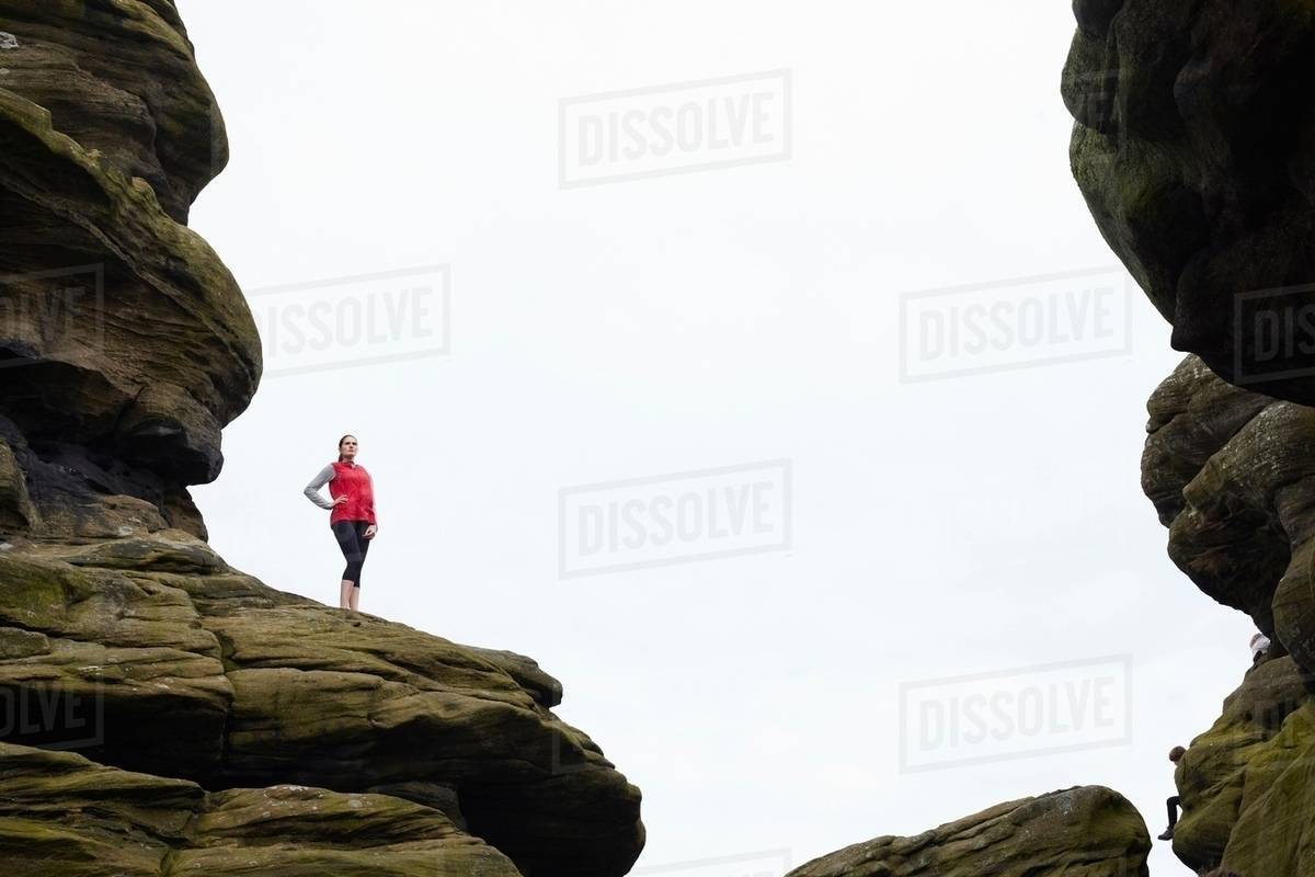 Woman standing on rock formations - Royalty-free Stock Photo | Dissolve