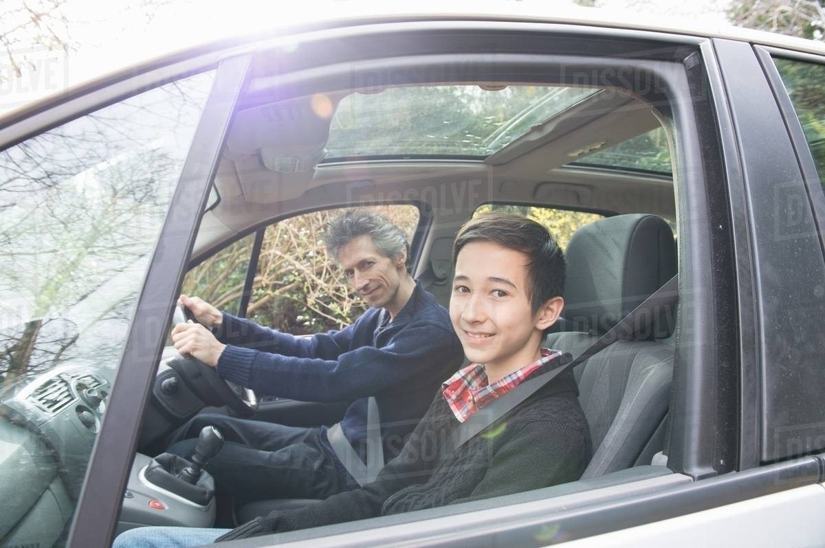 Portrait of mature man and teenage son driving a car - Royalty-free ...