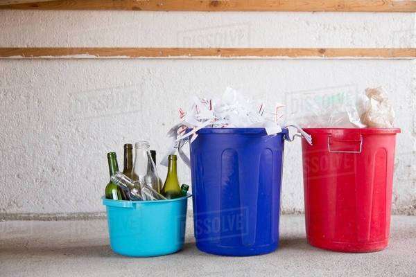Three recycling buckets in garage with bottles, paper and plastic ...