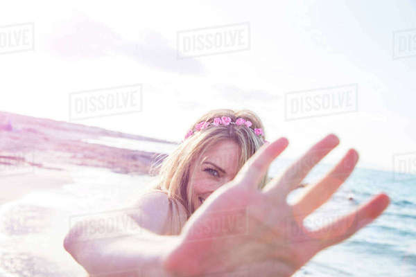 Woman covering face on beach - Royalty-free Stock Photo | Dissolve