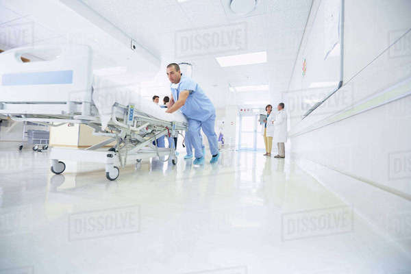 Medics urgently pushing hospital bed along corridor - Royalty-free ...