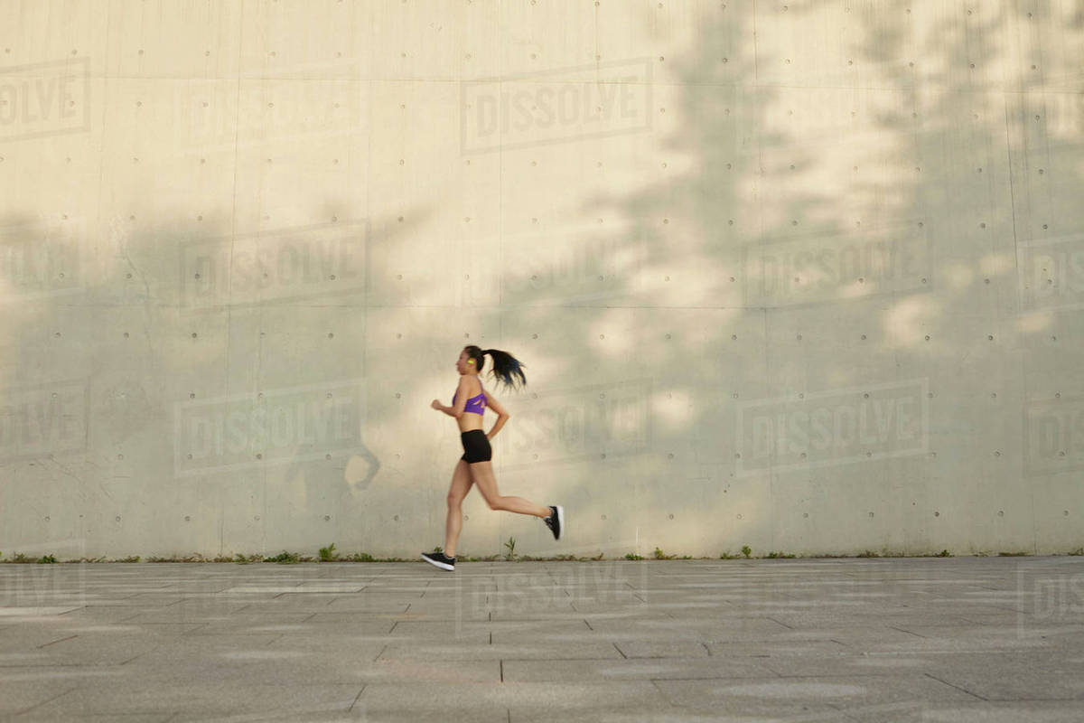 Side view of woman jogging - Royalty-free Stock Photo | Dissolve