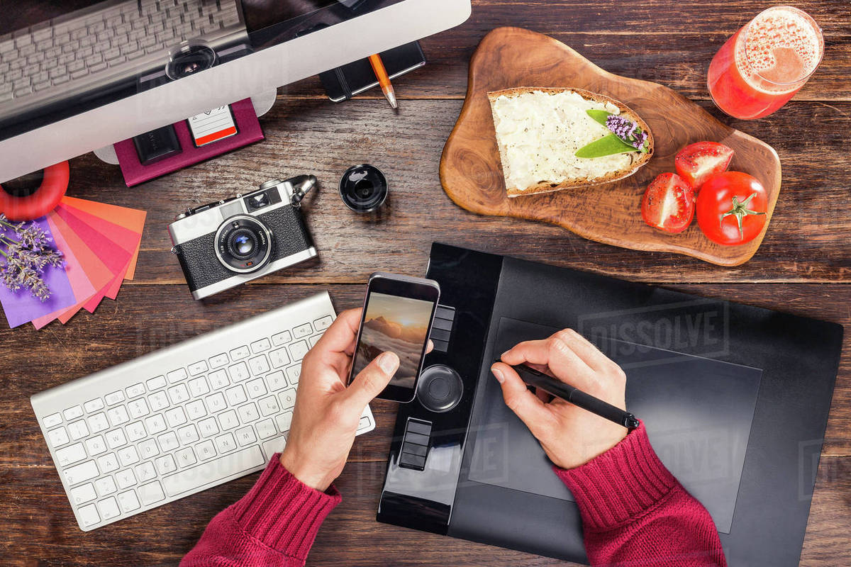 Overhead view of male hands editing photographs from smartphone on ...