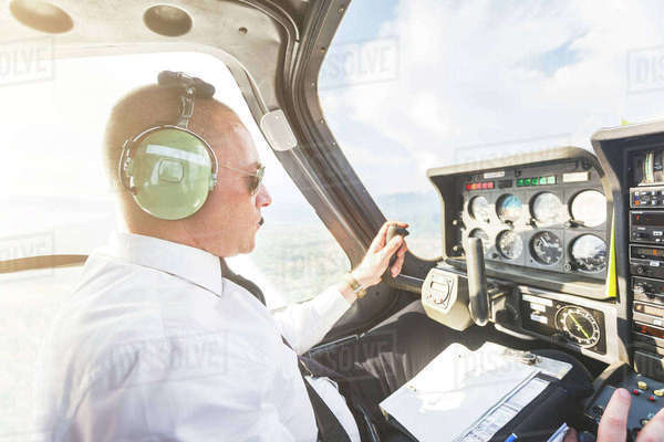 Pilot in cockpit of aircraft, in flight - Stock Photo - Dissolve
