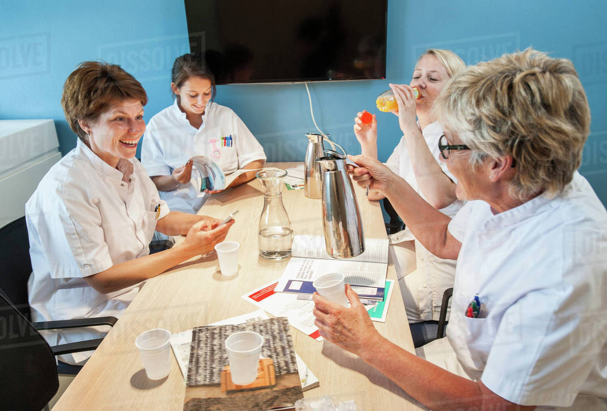 Nurses sitting at table at break time, chatting - Royalty-free Stock ...