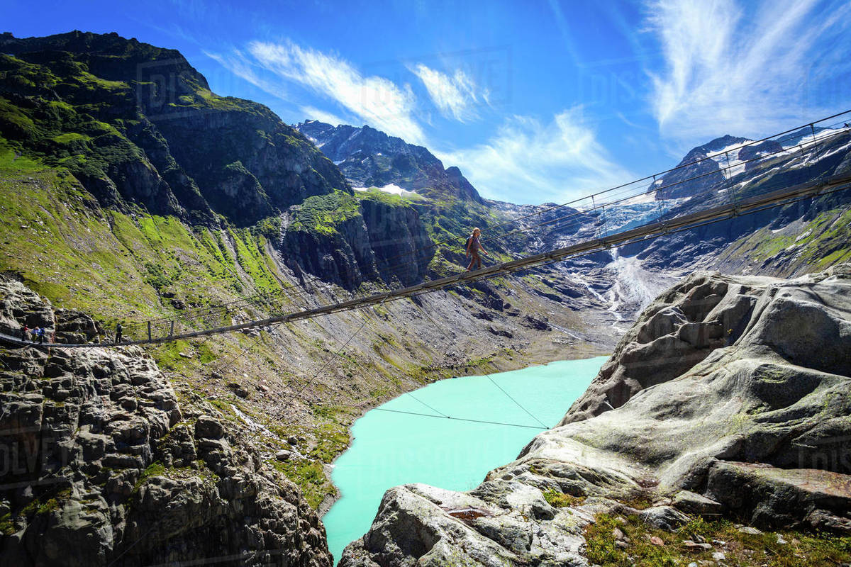 Tourist crossing Trift Bridge, Switzerland - Royalty-free Stock Photo ...