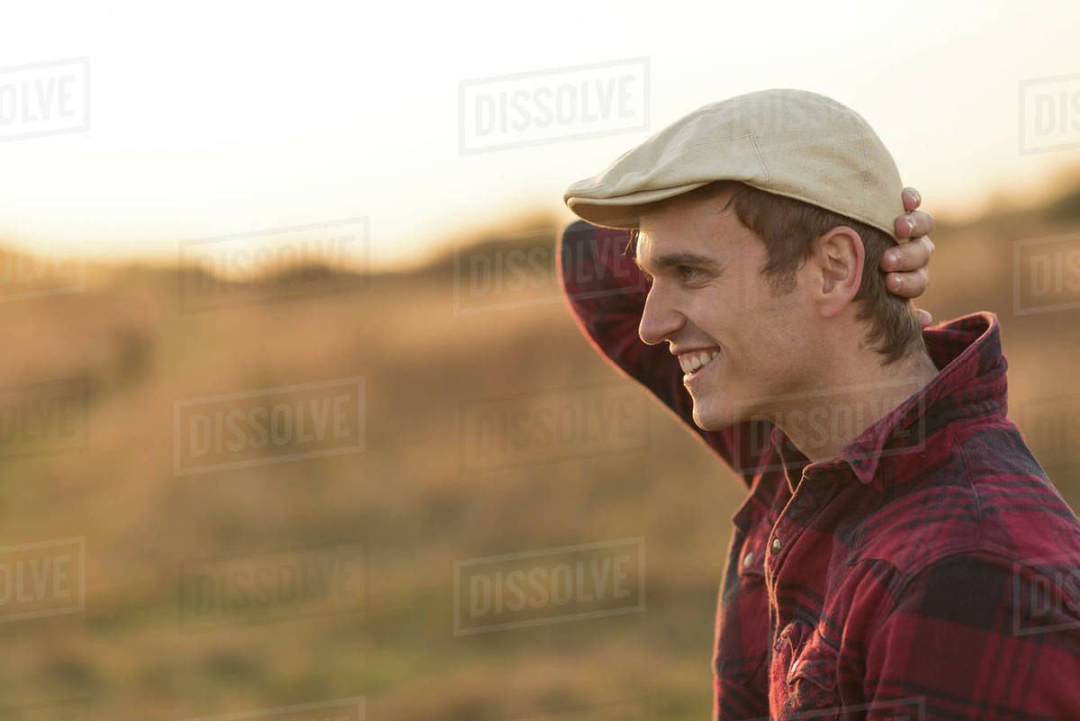 Young man in rural setting, smiling, side view - Royalty-free Stock ...