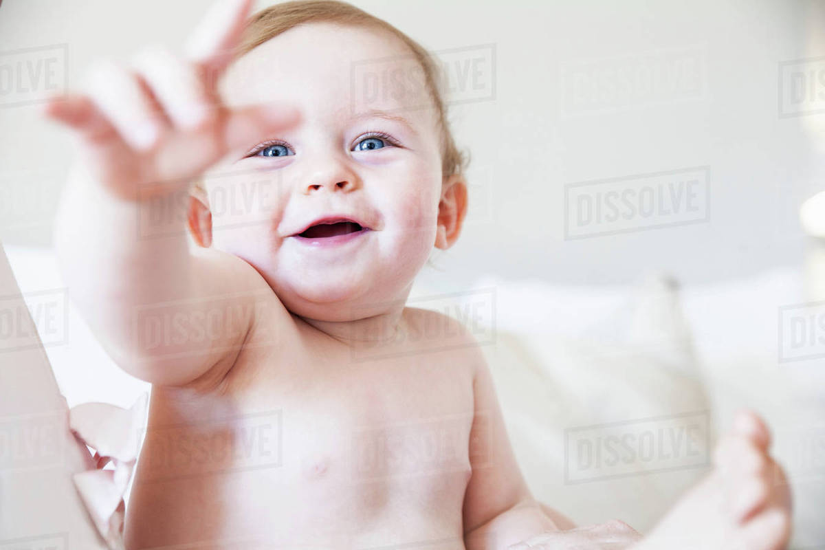 Portrait of happy baby boy pointing from bed - Royalty-free Stock Photo ...