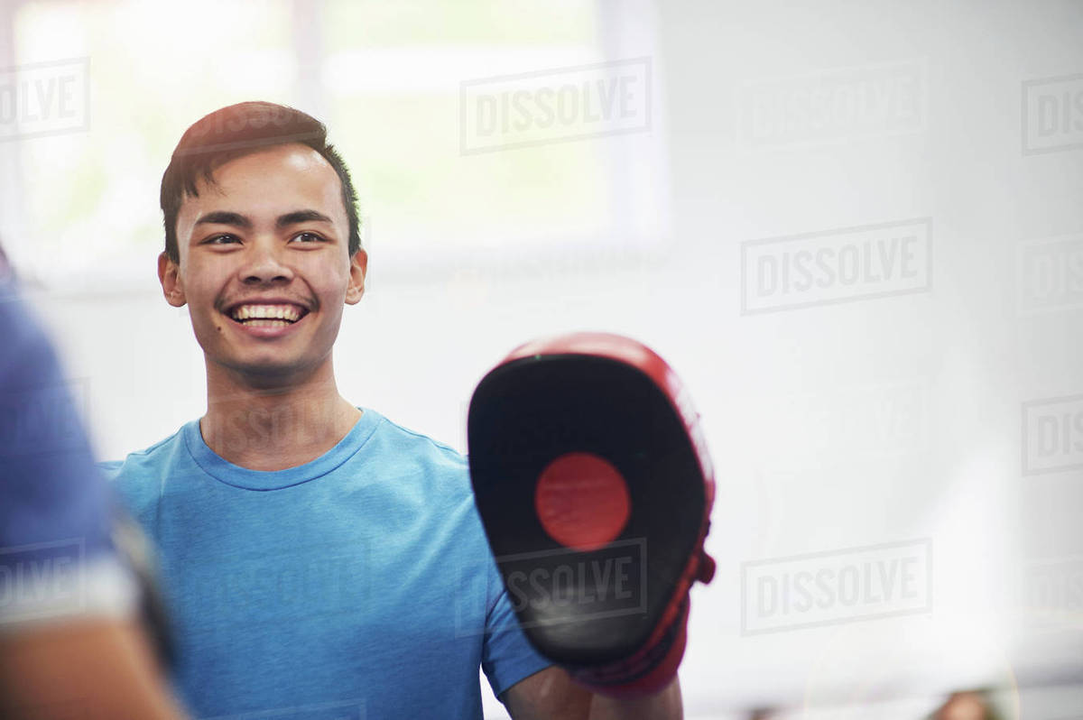 Male boxer wearing punch mitt training with teammate - Stock Photo ...